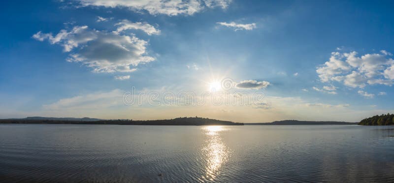 Blue Sky and Wispy White Clouds and Sun Over the River Stock Photo ...
