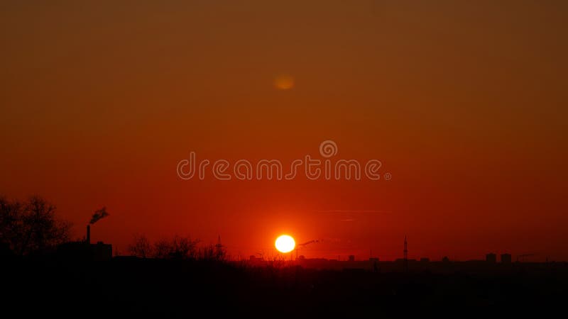 Orange Sunset Framing Urban Skyline with Rising Smoke Stock Image ...