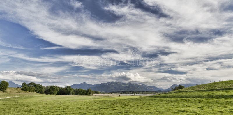 Panoramic Shot of a Landscape of a Green Field with Mountains on the ...