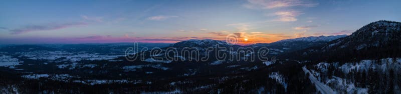 A Panoramic Shot of the Sun Setting Behind a Mountain Ridge that ...