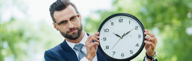 Shot of Young Man Holding Clock and Looking at Camera Stock Image ...