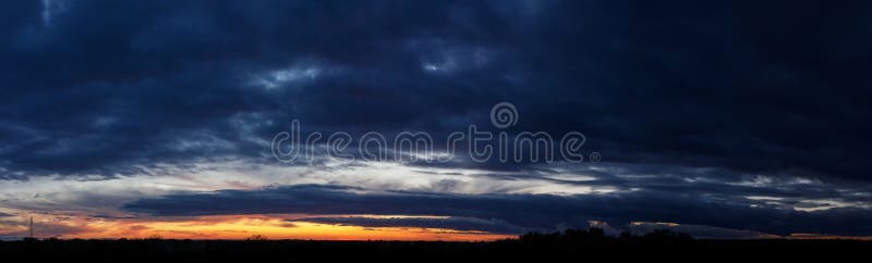 Panoramic Sunset Sky with Heavy Dark Blue Clouds and Orange Line of Sun ...