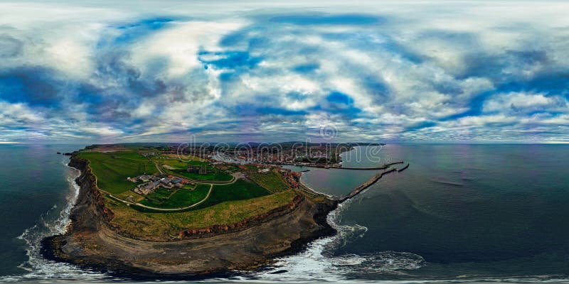 Panoramic View of Coastal Town with Cliffs, Ocean, and Dramatic Sky in ...