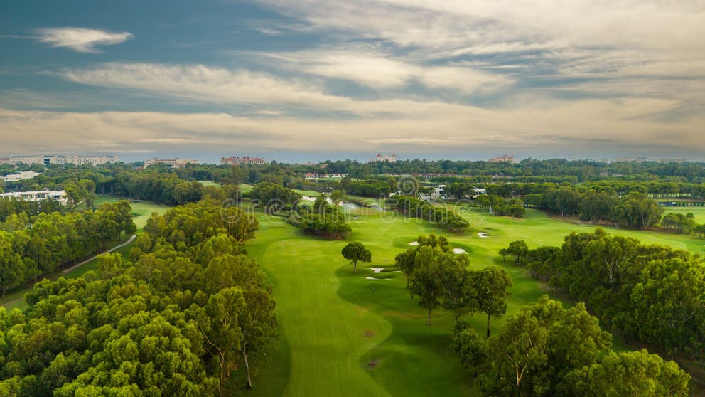 A Panoramic View of a Golf Course with Lush Greenery and a Cloudy Sky ...