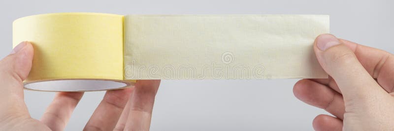 Paper Adhesive Tape on White. a Roll of Paper Duct Tape in the Hands of ...