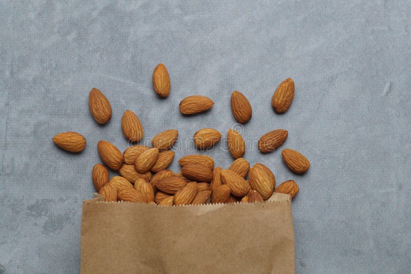 Paper Bag with Delicious Almonds on Grey Table, Top View Stock Photo ...