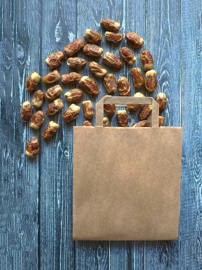 Paper Bag with Scattered Dates on a Dark Wooden Table. Stock Photo ...