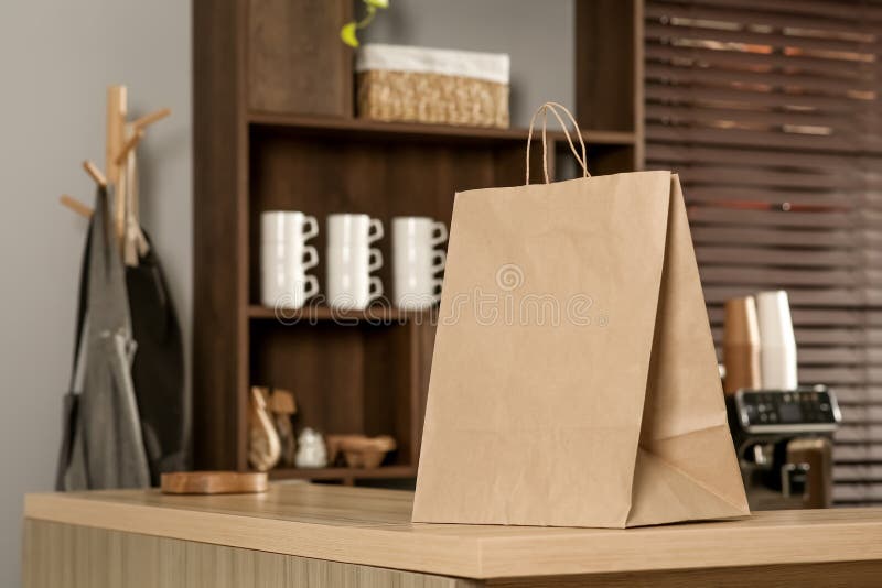 Paper Bag on Wooden Counter in Cafe, Space for Text Stock Photo - Image ...