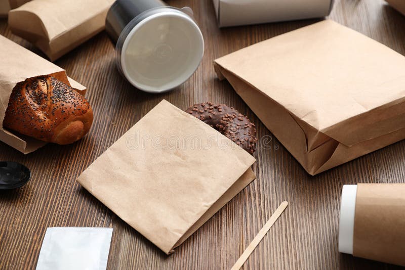 Paper Bags and Different Takeaway Items on Wooden Table Stock Photo ...