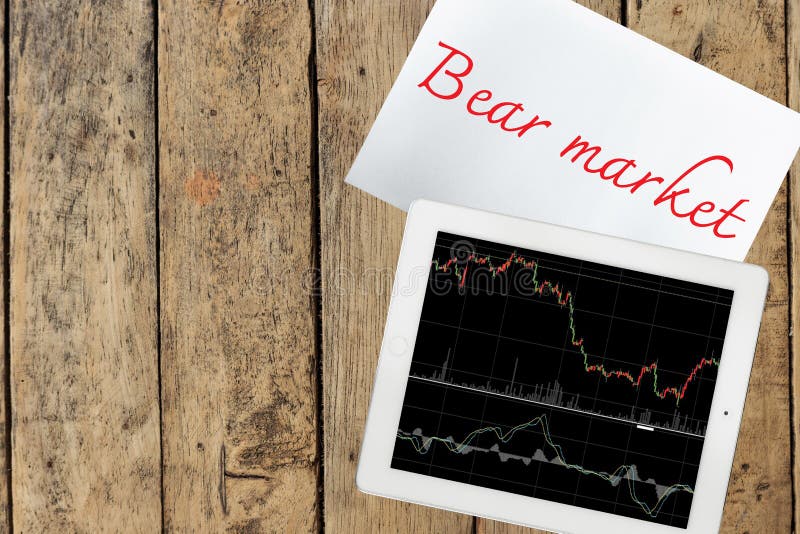 Paper with Bear Market Text and Tablet with Graph on Wood Table Stock ...