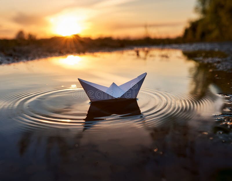 A Paper Boat Set Afloat in a Shallow Puddle, Reflecting Soft Evening ...