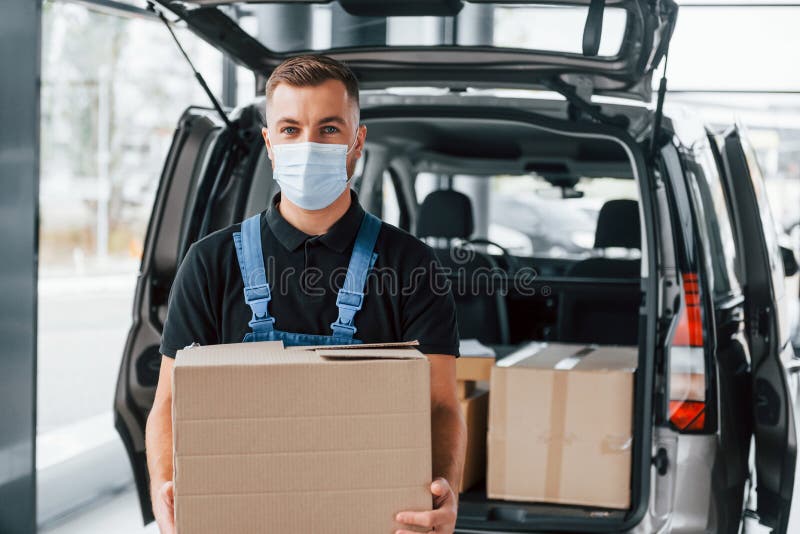 Paper Box. Delivery Man in Uniform is Indoors with Car and with Order ...