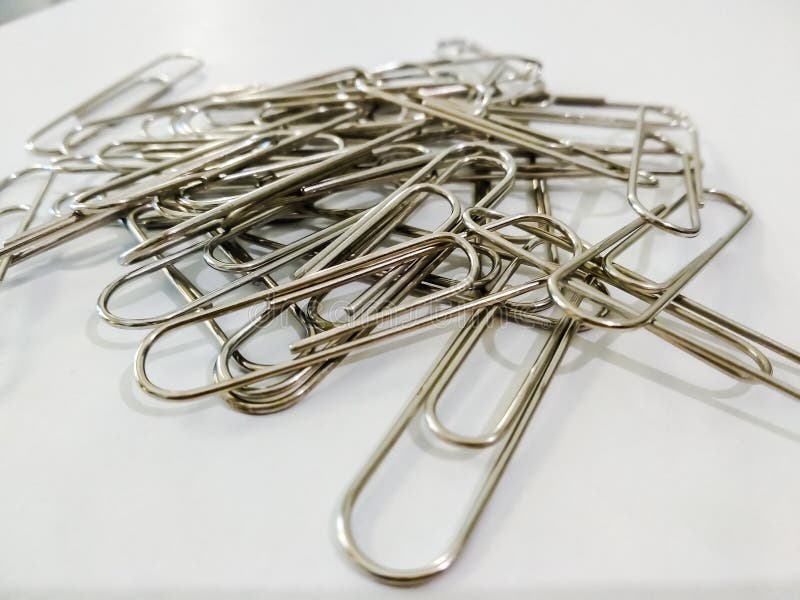 Paper clips on white paper stock photo. Image of weapon - 220833144