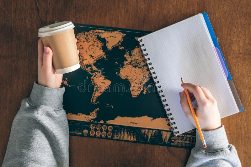 A Paper Cup in Female Hands, an Empty Notepad and a World Map on a ...