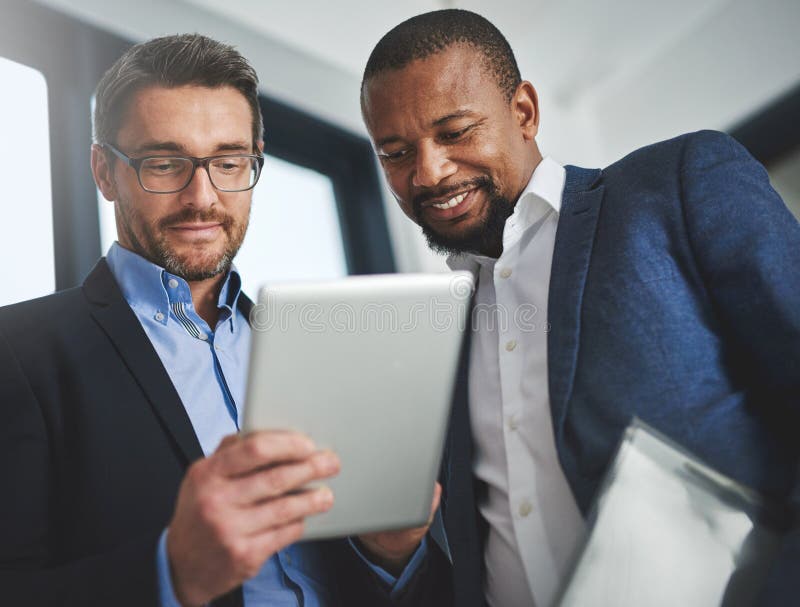 Less Paper, More Planning. Two Businessmen Using a Digital Tablet ...