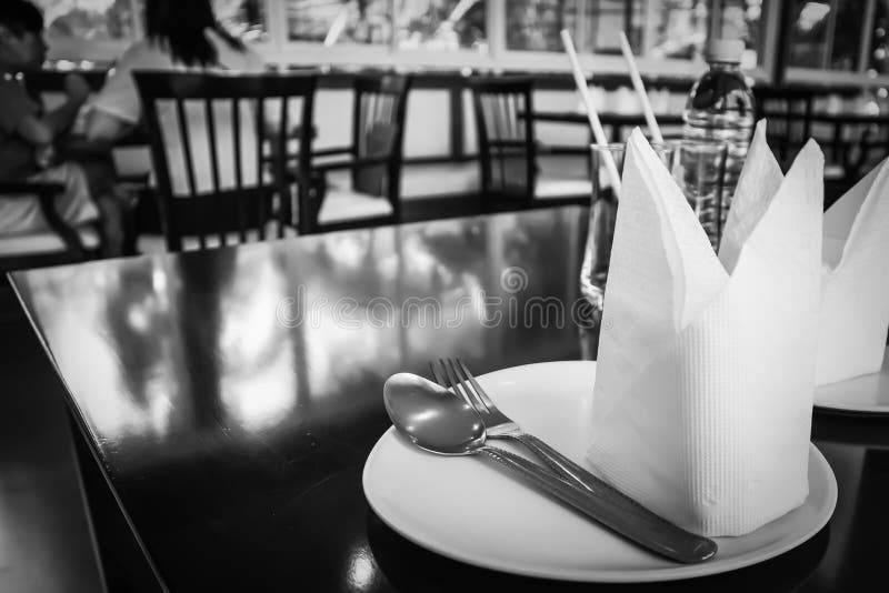 Paper Napkins, Fork and Spoon in White Plate on the Table and in ...
