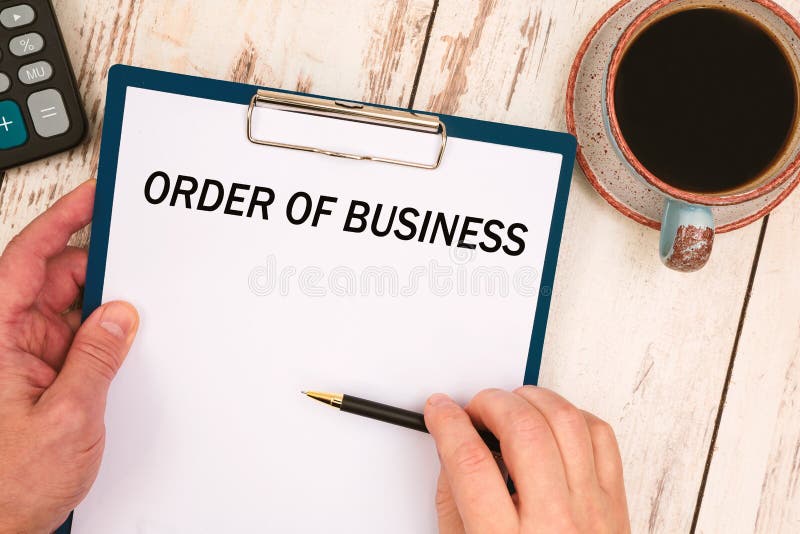 Paper with Text Order of Business on the Table, Calculator and Cup of ...