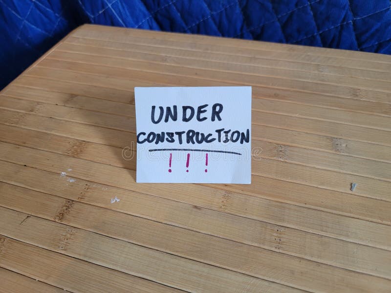 Paper Under Construction Sign on Brown Wood Table Stock Photo - Image ...