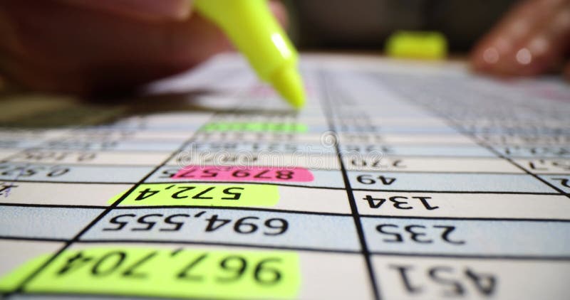 Paperwork and Hand Making Notes with Pink and Yellow Marker on Sheet of ...