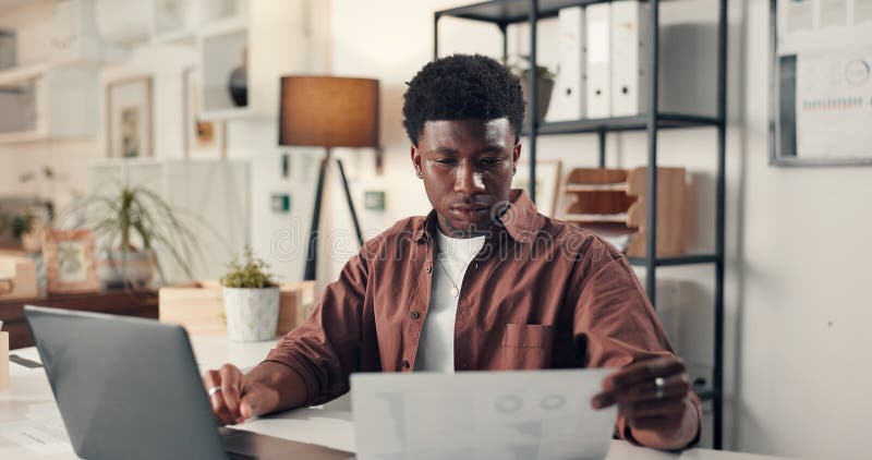 Paperwork, Laptop or Black Man Reading in Office for Review, Platform Engagement and Charts or ...