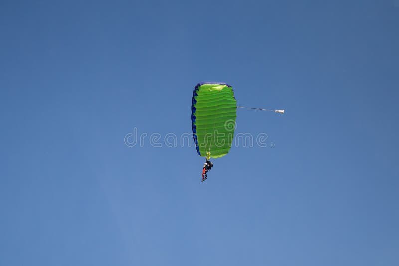 Parachutists: Instructor and Beginner with Green Parachute Against ...