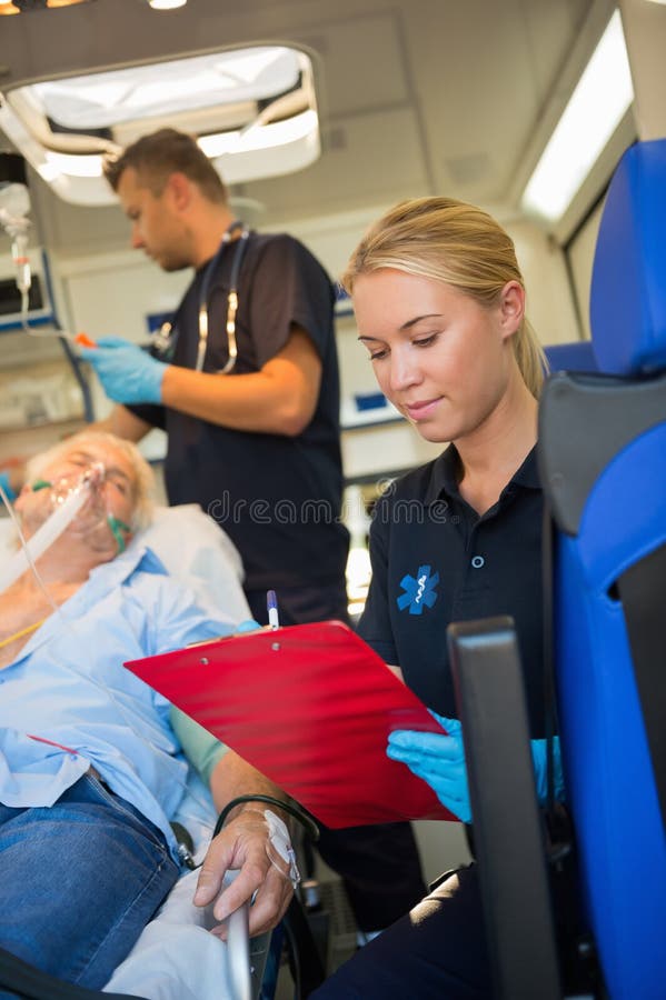 Paramédico Con El Equipo Que Ayuda Al Paciente Herido Foto de archivo ...