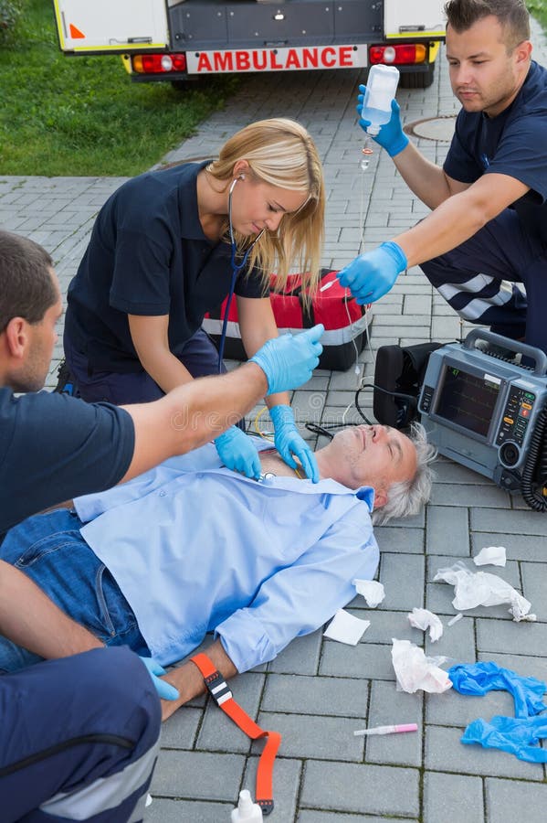 Paramedics Examining Unconscious Man Stock Photo - Image of ground ...