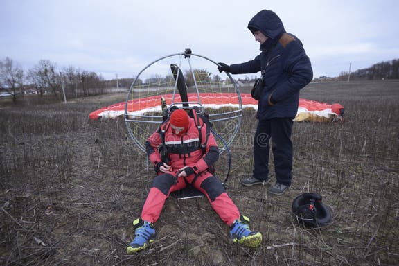 Paramotoring. Instructor Starting the Engine of Paramotor by Turning ...