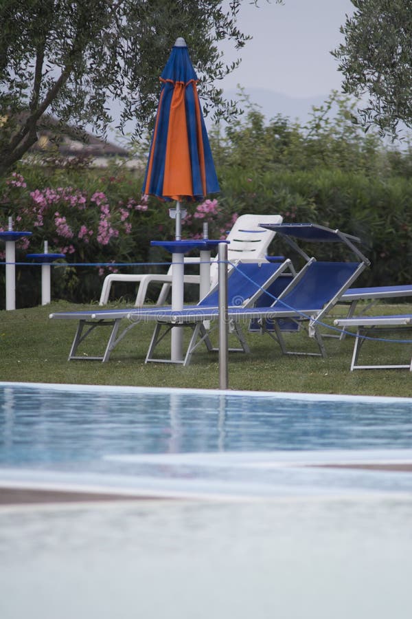 Parasol and Deck Chairs by the Pool Stock Photo - Image of umbrella ...