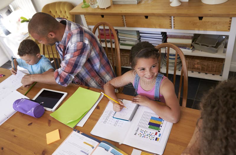 Des Parents Aidant Leurs Enfants à Faire Leurs Devoirs à Table Image ...