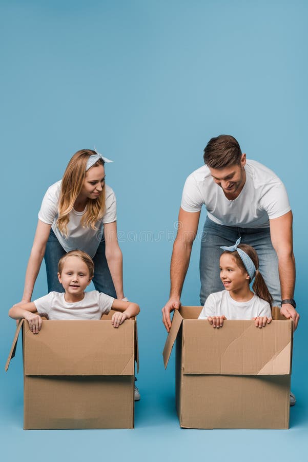 Parents with Cheerful Kids in Cardboard Boxes for Relocation on Blue ...