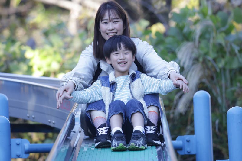 Parents and Children Playing on a Slide Stock Image - Image of family ...