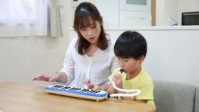 Parents and Children Practicing Keyboard Harmonica Stock Footage ...
