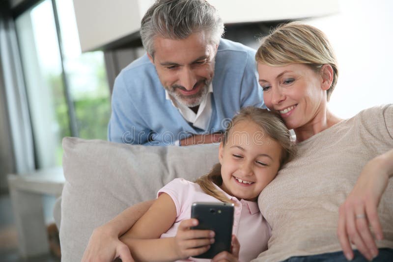 Parents with Daughter Playing on Smartphone Stock Image - Image of ...
