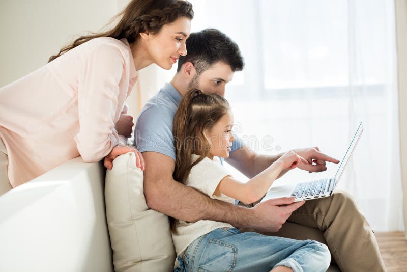Parents and Daughter Using Laptop at Home Stock Image - Image of ...