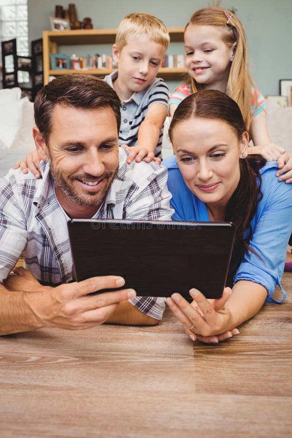 Parents with Digital Tablet while Children Sitting on Their Back Stock ...