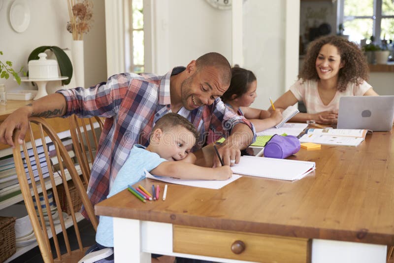 Parents Helping Children with Homework at Table Stock Photo - Image of ...