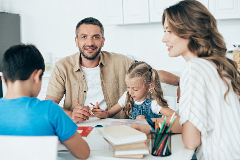 Parents Helping Children with Homework at Table Stock Image - Image of ...