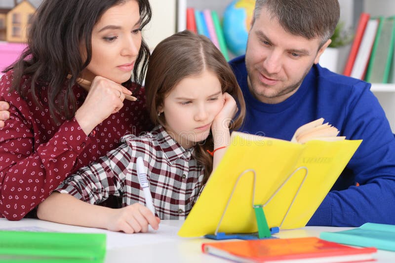 Parents Helping Daughter with Lessons Stock Photo - Image of caucasian ...