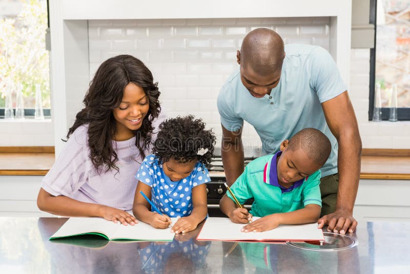 Parents Aidant Leurs Enfants Faisant Leurs Devoirs Image stock - Image ...