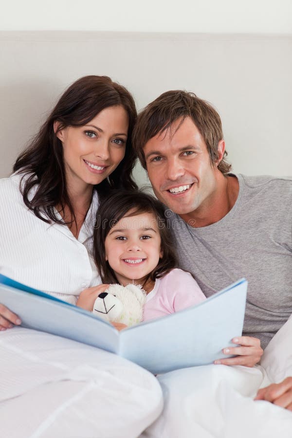 Parents Reading a Story To Their Daughter Stock Photo - Image of lovely ...