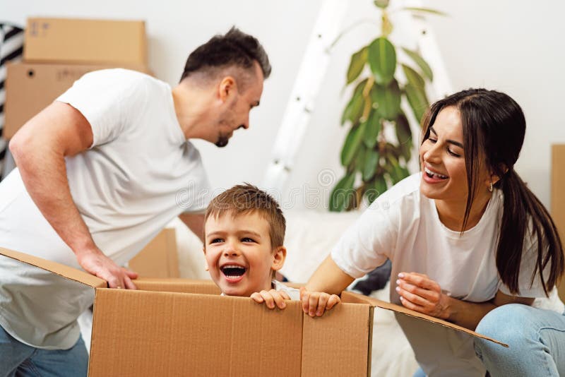 Parents and Son Packing Boxes and Moving into a New Home Stock Photo ...