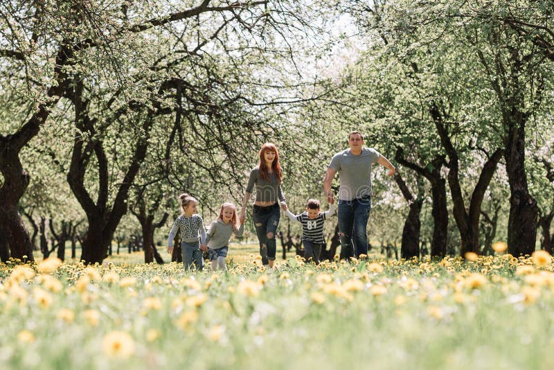 Parents with Their Children Run in the Spring Garden Stock Photo ...