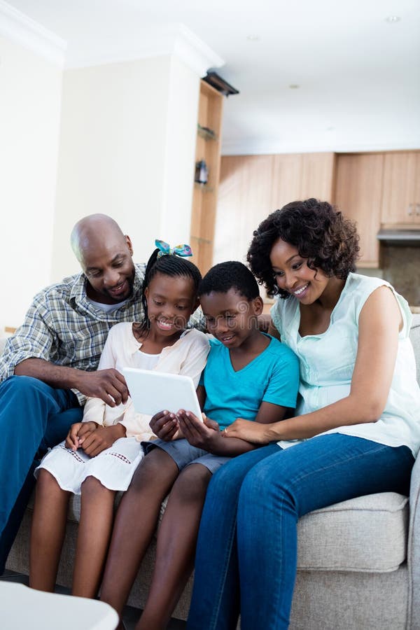 Parents and Their Children Using Digital Tablet in Living Room Stock ...