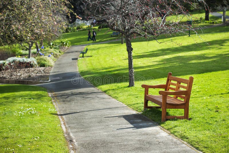 Park Bench and Path Leading To Out of Focus Figure Stock Photo - Image ...