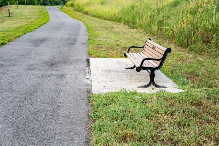Park Bench by a Walking Path Stock Photo - Image of lush, pristine ...