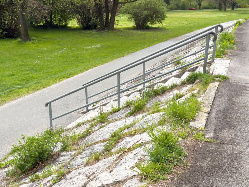 Park Path with Metal Railing and Overgrown Grass in Spring Stock Photo ...