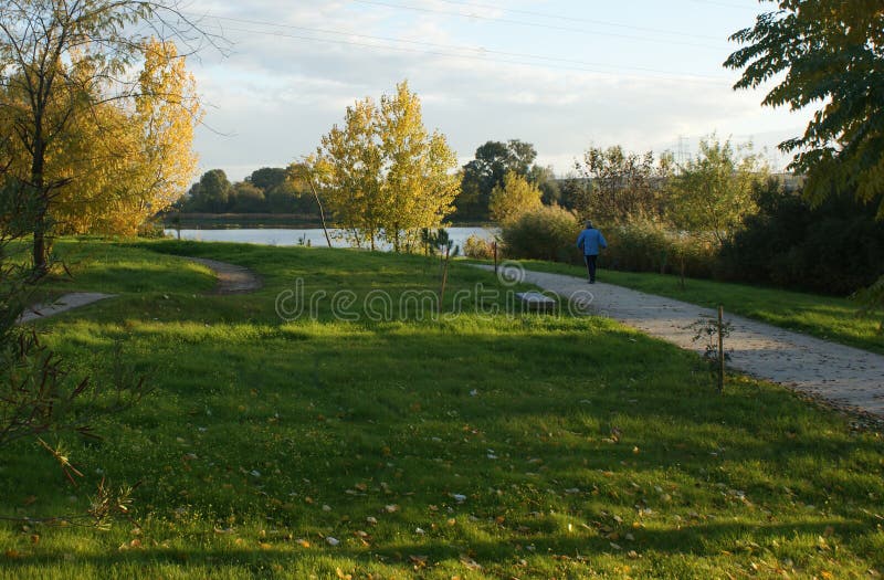 Park with Path To the River and Man Walking on an Autumn Sunset Stock ...