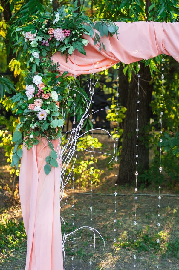 A Part of Wedding Arch Decorated with Flowers and Pastel-colored Cloth ...