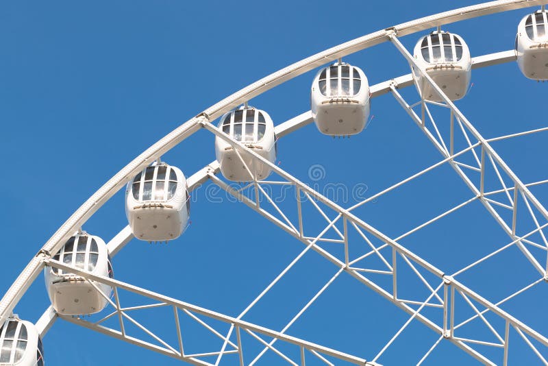 White Ferris Wheel with Glass Light Blue Cabins Against Blue Sky, Dubai ...